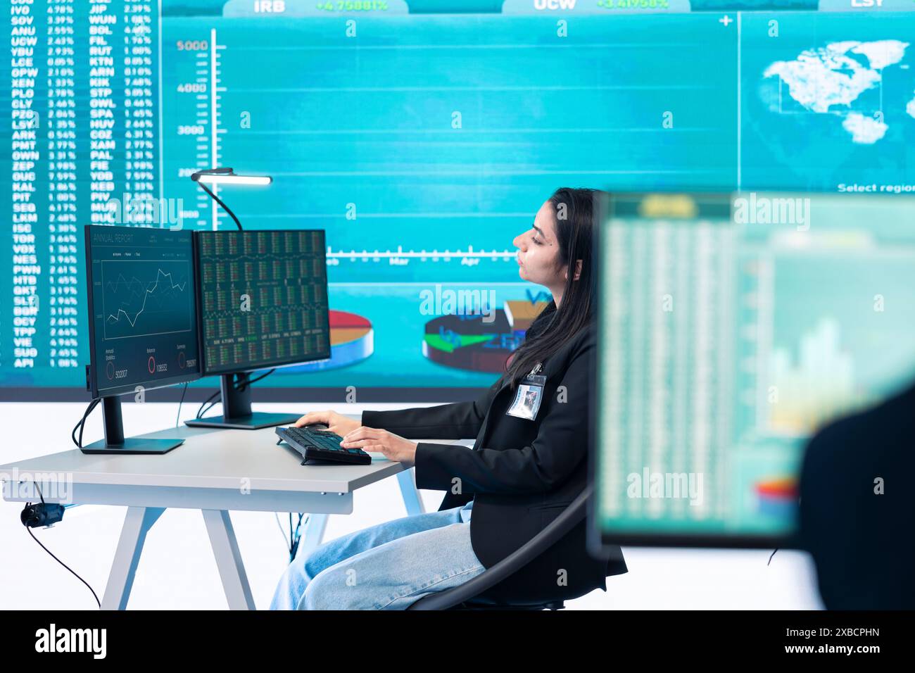 Enterprise analyst reviewing infographics numbers on a big screen at ...