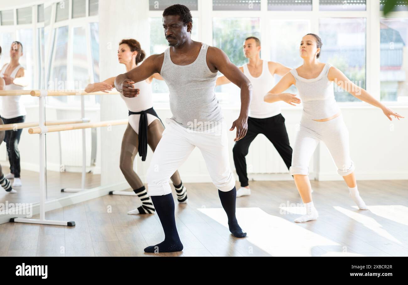 African American male ballet dancer mastering moves during group ...