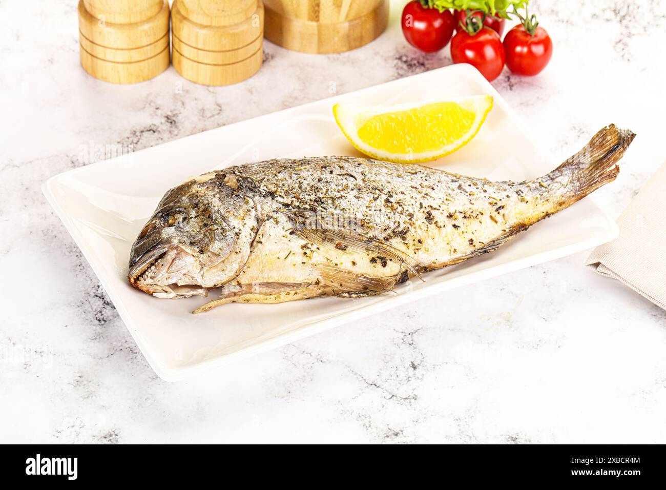 Baked Dorado fish served lemon slice Stock Photo - Alamy