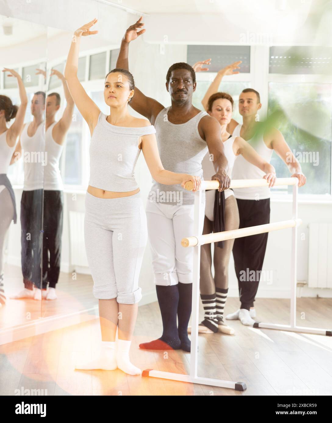 Group of dancers stand in third position at barre Stock Photo - Alamy