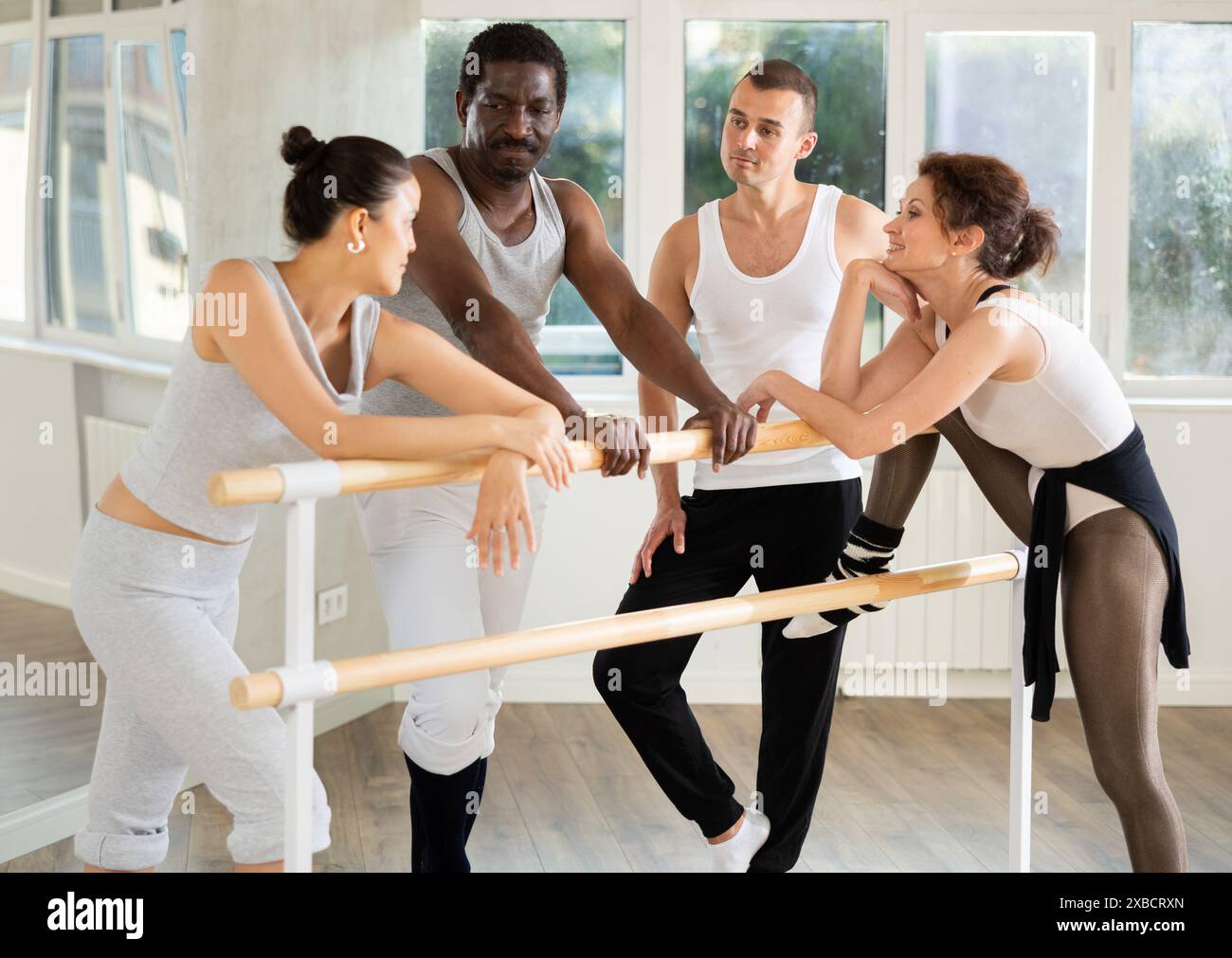 Group of dancers talking at ballet barre Stock Photo - Alamy