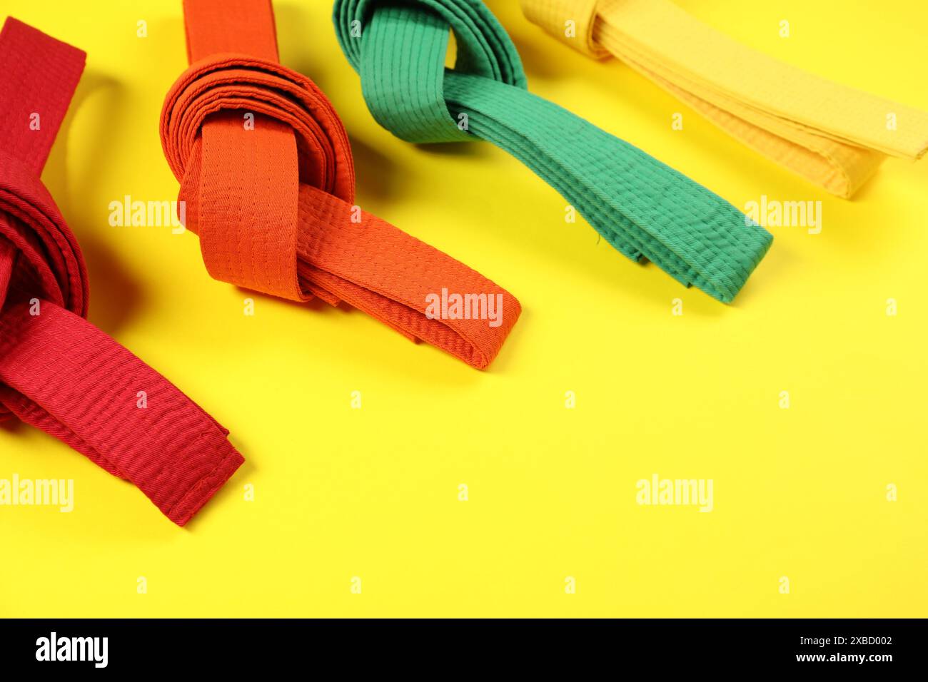 Colorful karate belts on yellow background, space for text Stock Photo ...