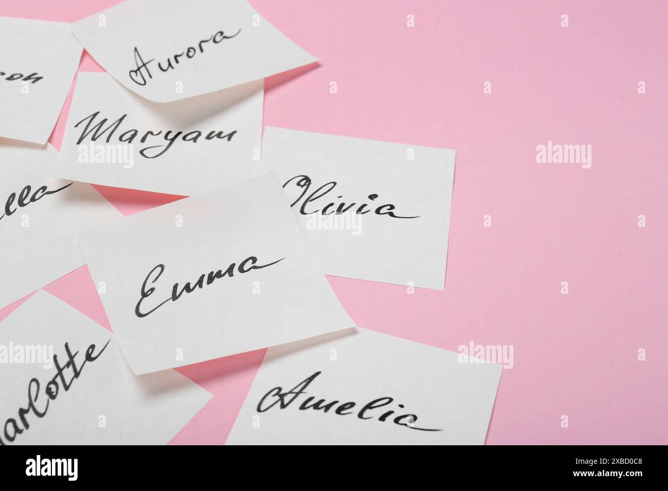 Paper stickers with different names on pink background, closeup and ...