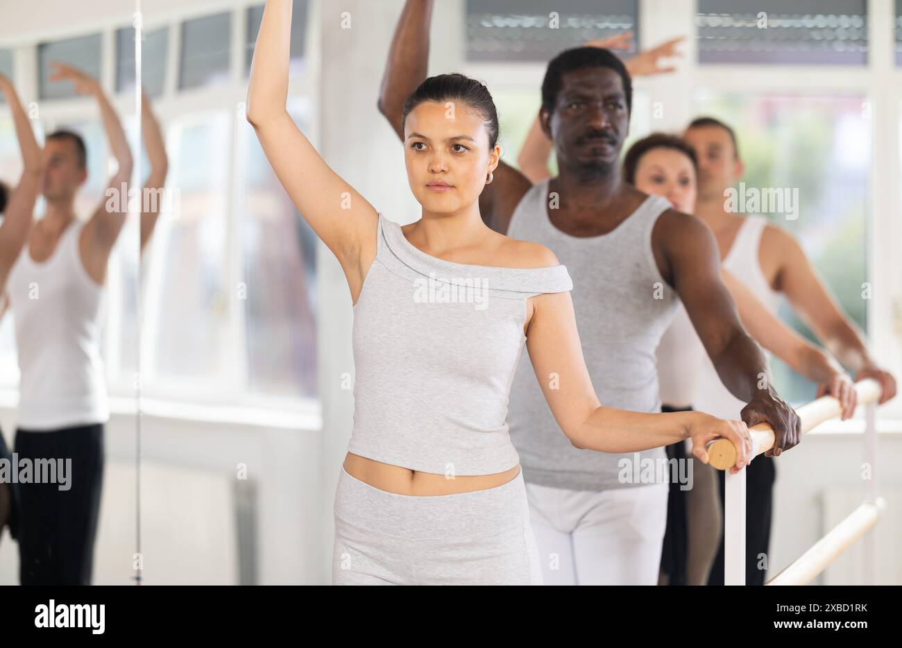 Group of dancers stand in third position at barre Stock Photo - Alamy