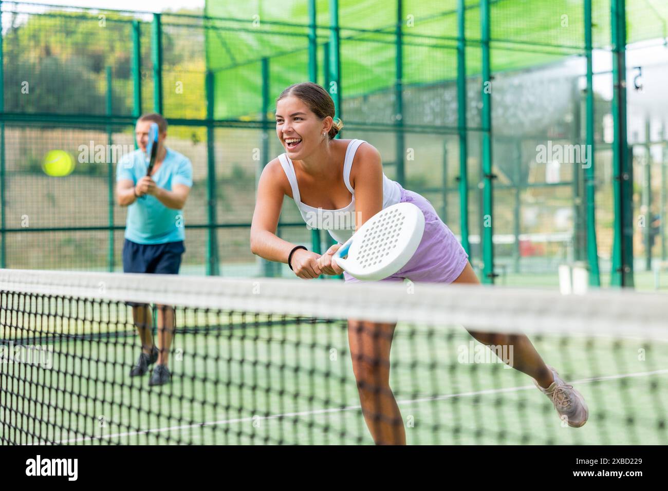 Padel game - woman with partners plays on tennis court Stock Photo - Alamy