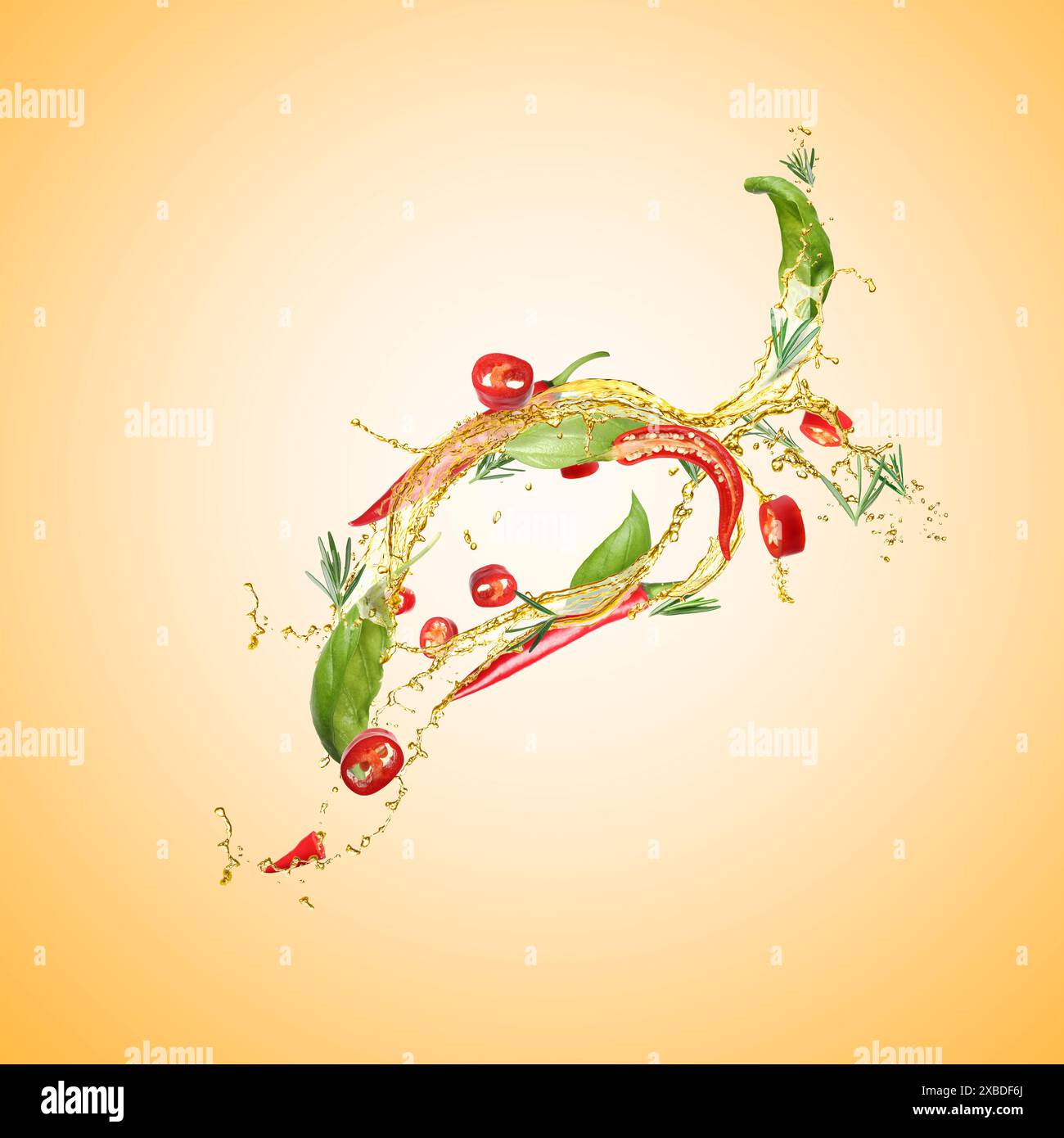 Cooking oil splash with chili pepper, basil and rosemary in air on ...