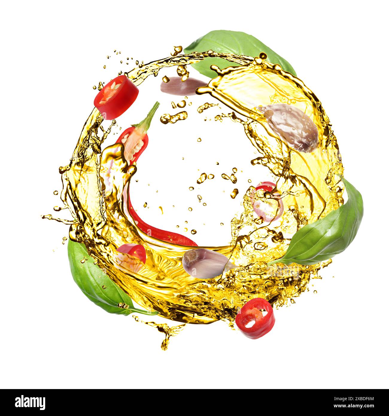 Cooking oil splash with chili pepper, garlic and basil in air on white ...
