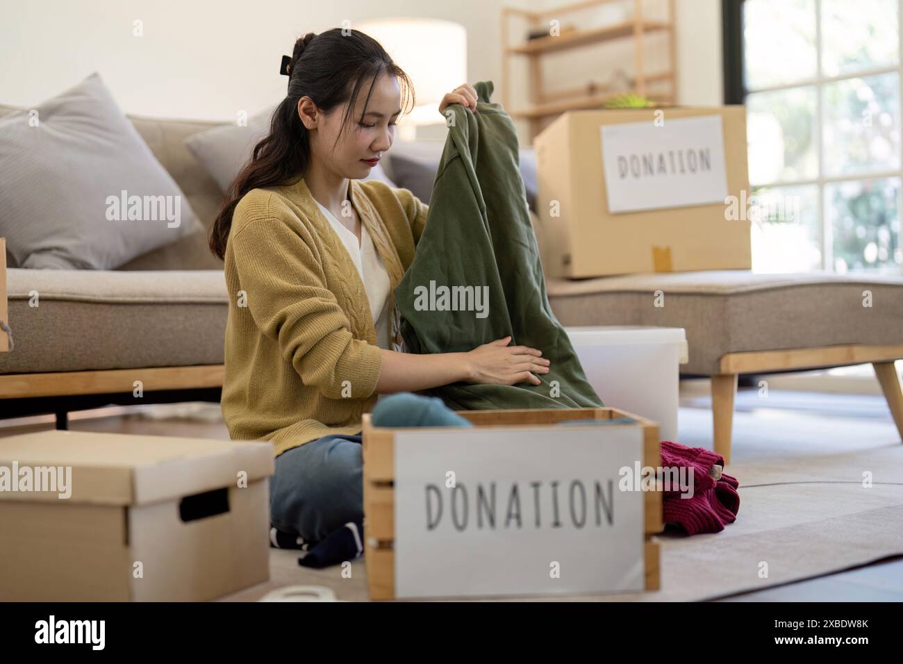 Volunteer Sorting and Donation Clothes for Charity in a Modern Living ...