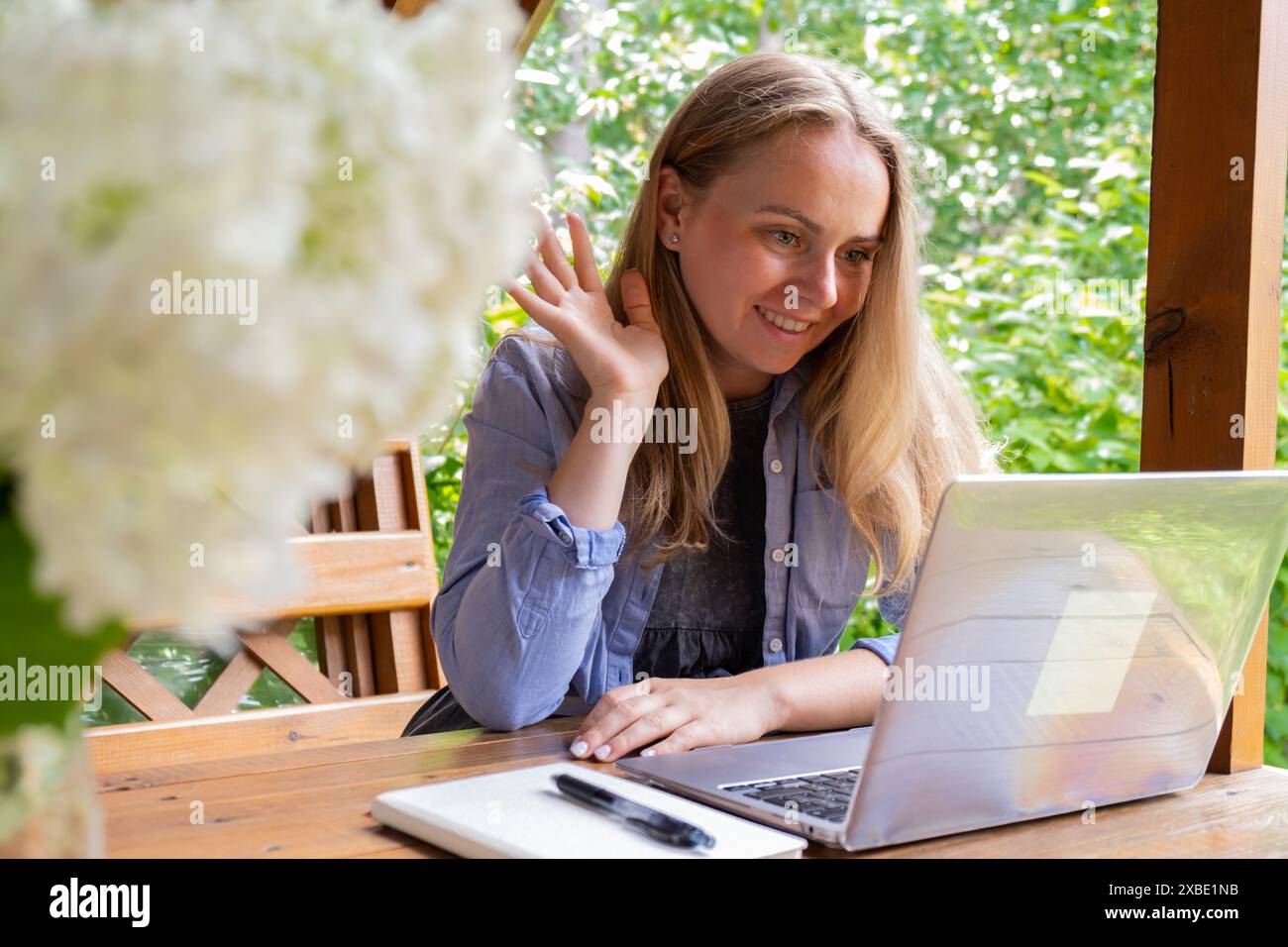 Female student has online lesson education outdoor in garden wooden ...