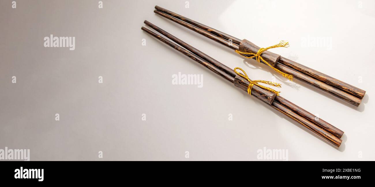 Two pairs of traditional bamboo sushi sticks, a banner with a place for ...