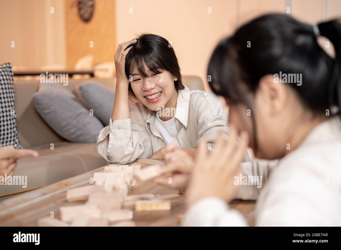 A cheerful, young Asian woman is laughing and enjoying playing a ...