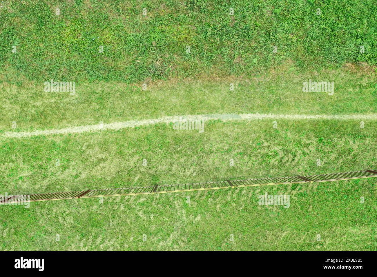 aerial top view of pathway on the green grass field texture. natural ...