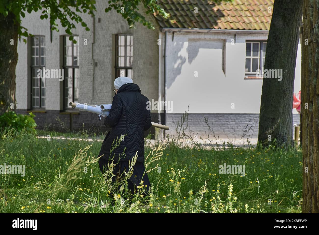 Bruges, Brussels; June,06,2024; An old nun walks through the convent ...