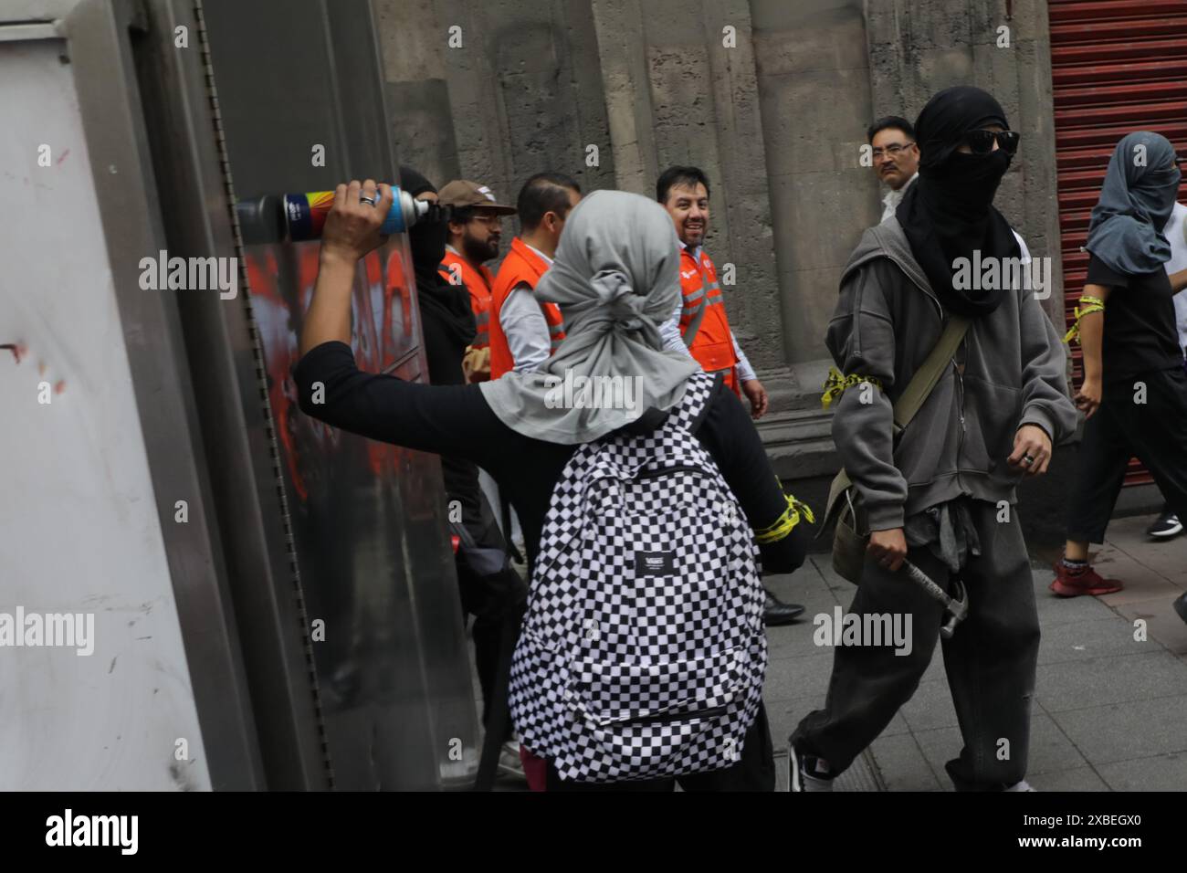 A hooded person hits a bus stop while takes part. during a protest to ...