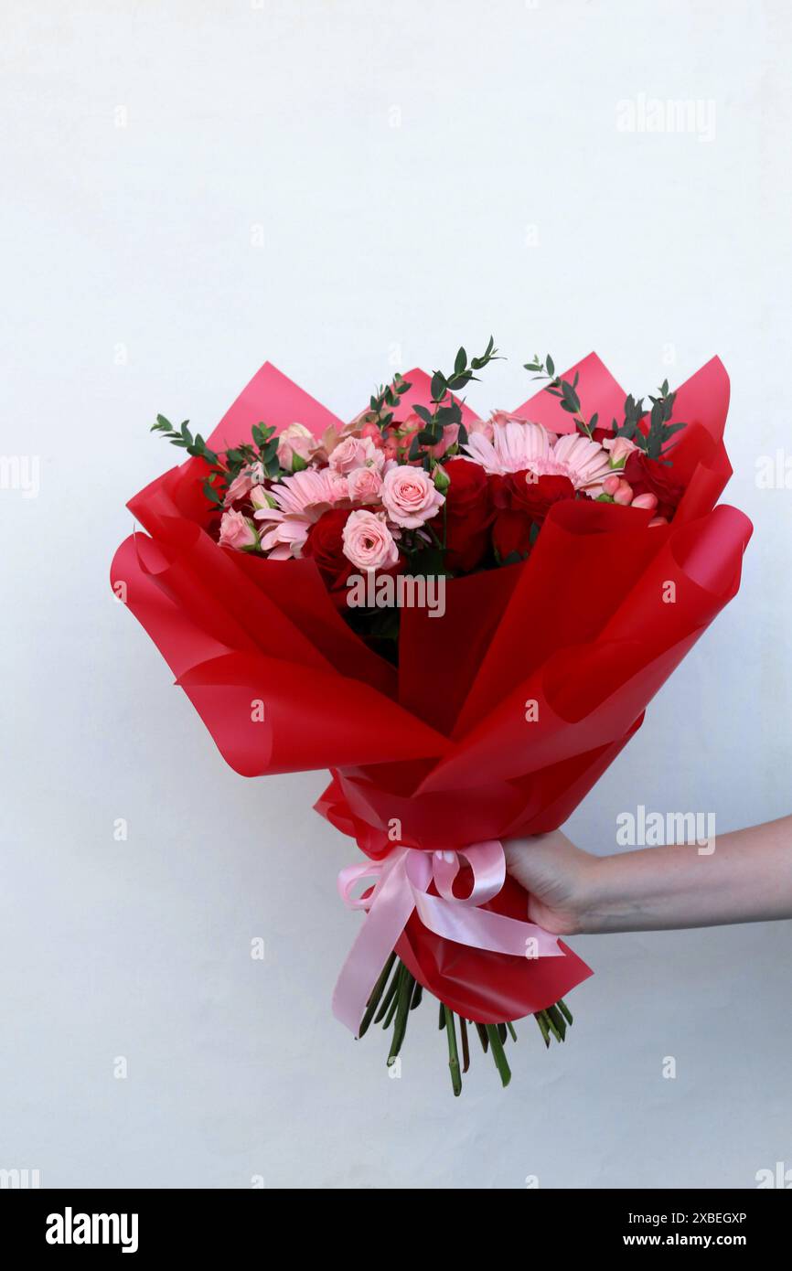 hand holding a beautiful bouquet of flowers on a plain background Stock ...