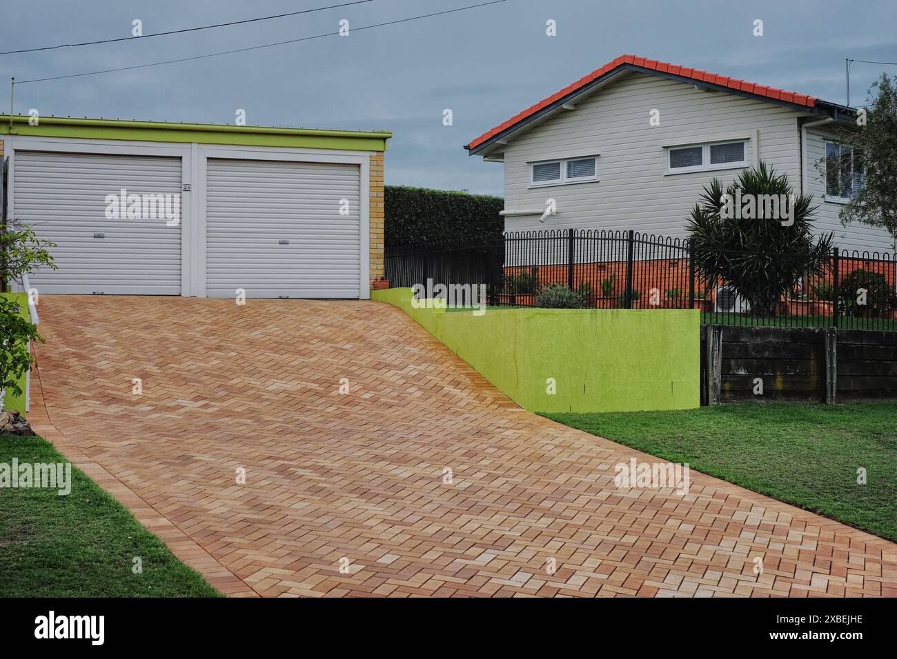 Brick driveway to a separate double car garage and a 1960s house in ...