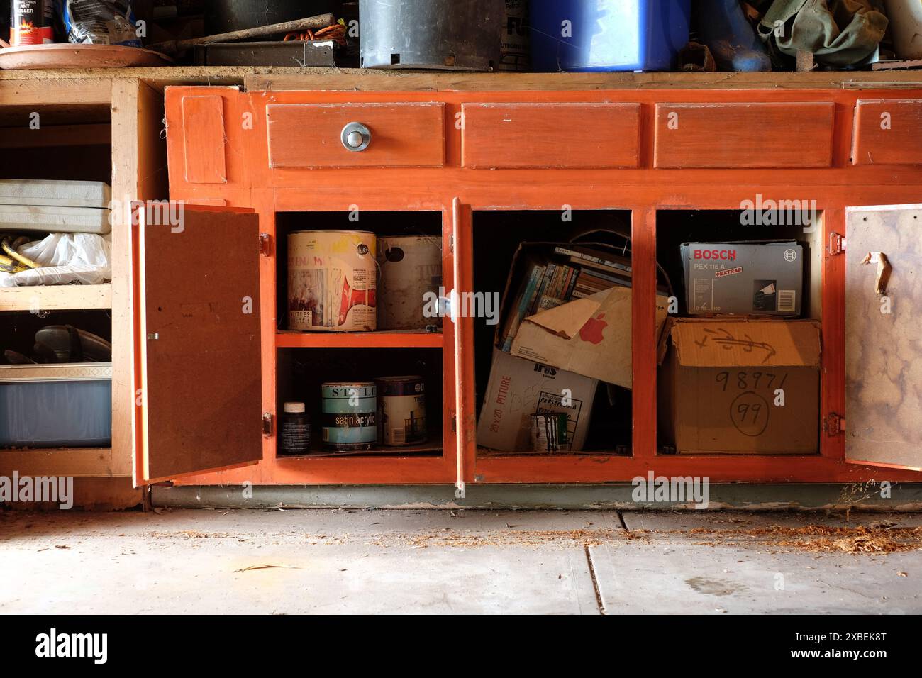 An old kitchen cupboard used as a storage unit in a houses garage, open ...