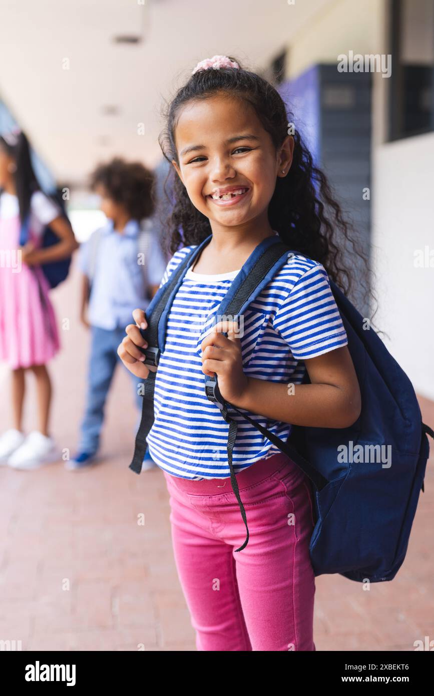 Biracial girl smiling with backpack, ready for school Stock Photo - Alamy