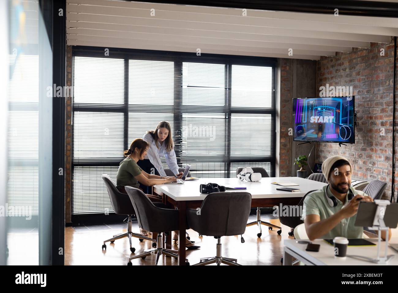 Asian businesswoman discussing project with young Caucasian woman in modern office. Large ...