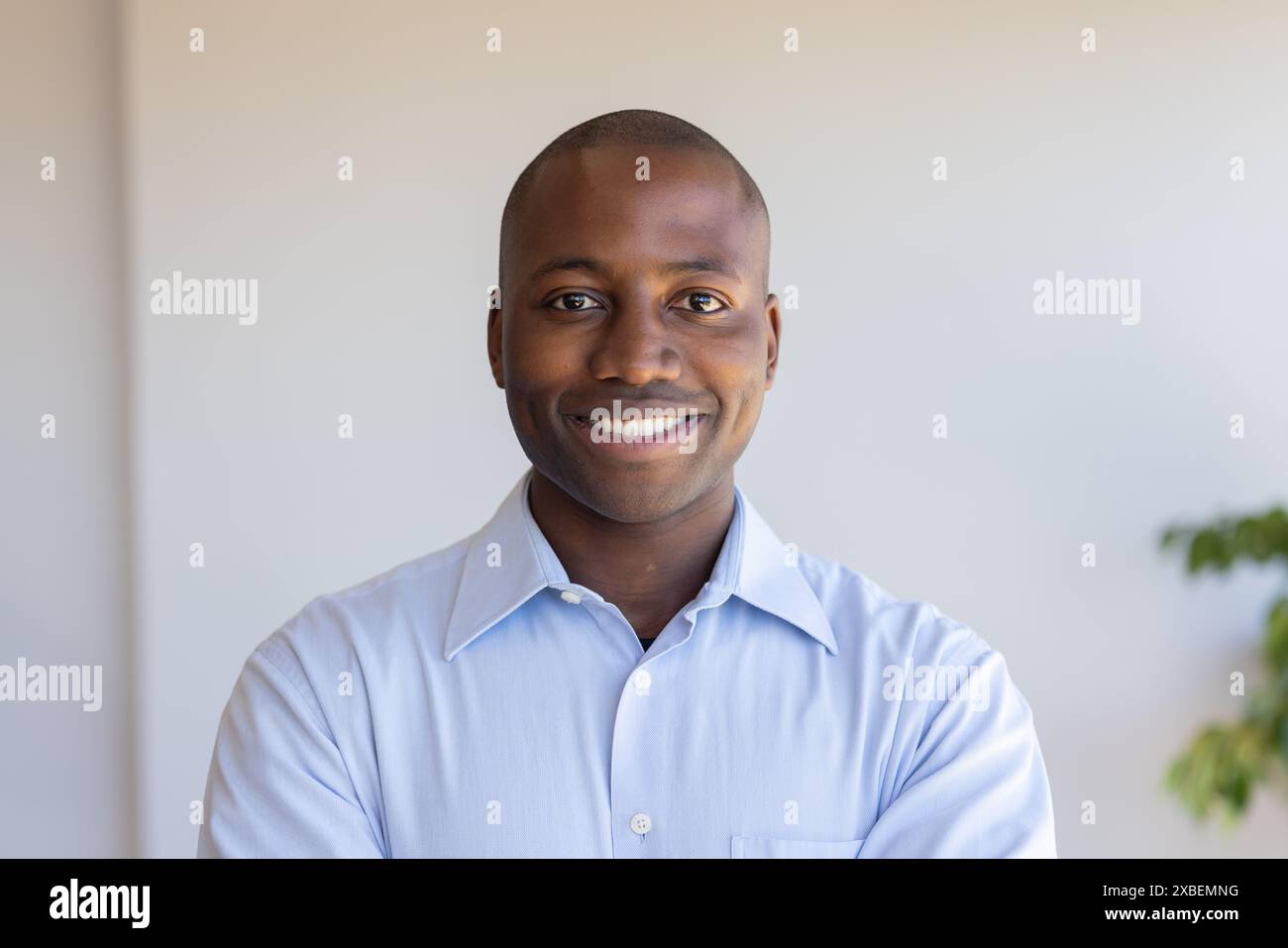Young African American man smiling confidently with arms crossed Stock Photo - Alamy