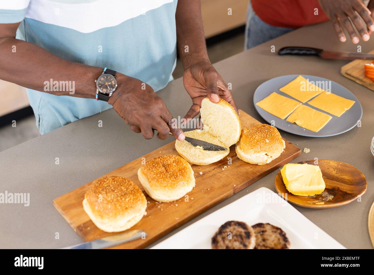 African American father and son preparing burgers together in kitchen ...