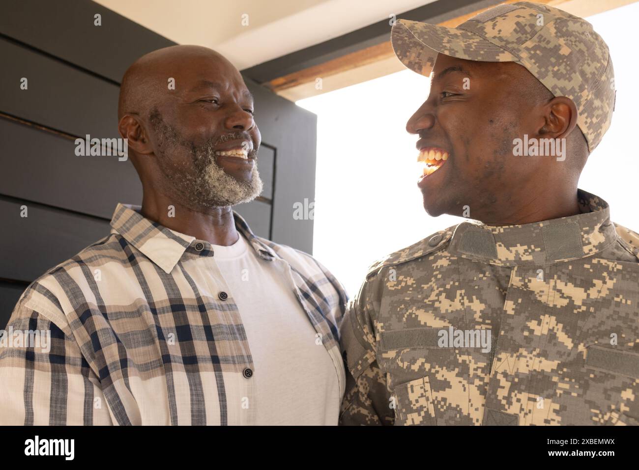 African American father and soldier son smiling at each other, soldier ...