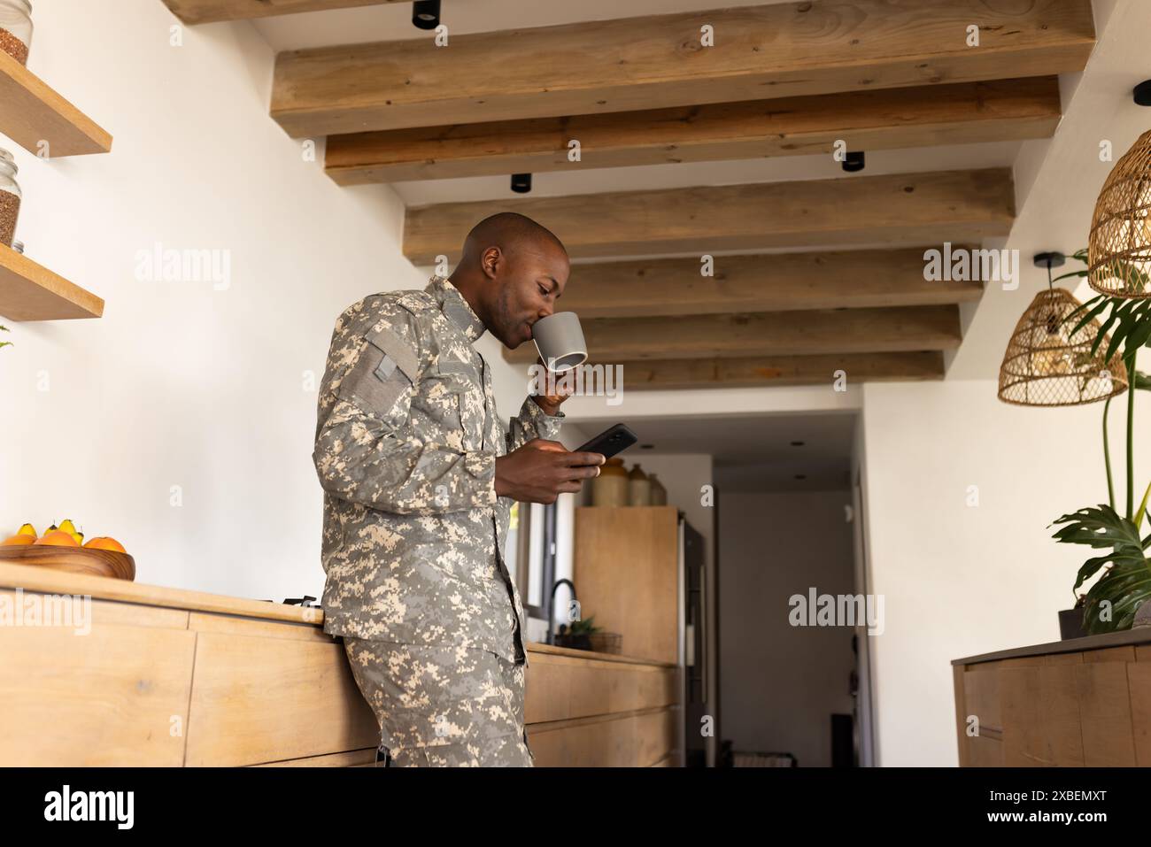 Young African American soldier in military uniform drinks coffee and ...