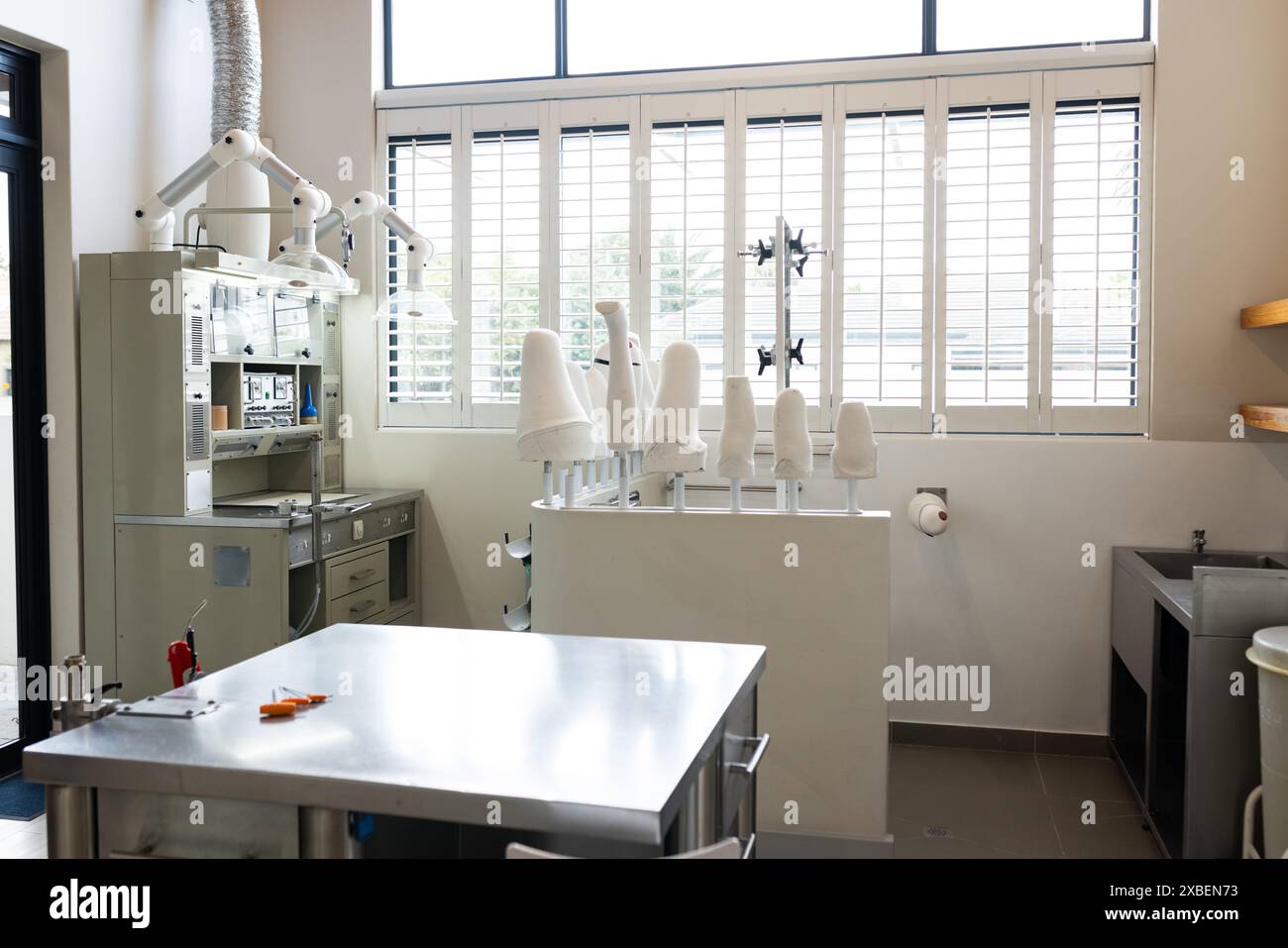 A modern prosthetic lab with various prosthetic limbs displayed on ...