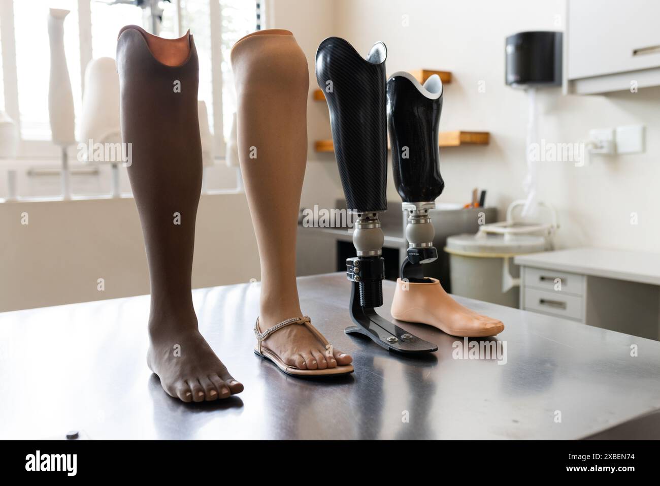 A diverse array of prosthetic legs displayed on metallic table in a lab ...