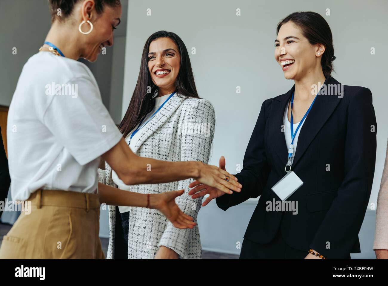 Female colleagues congratulating each other with joyful smiles in a ...