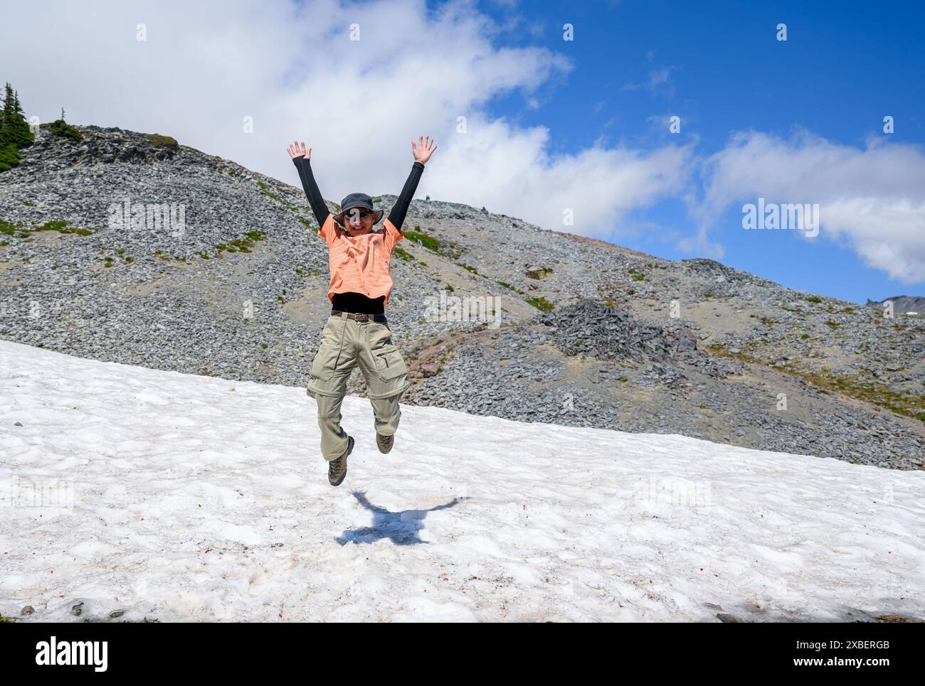 Man jumping on a patch of snow at Skyline Trail. Mt Rainier National ...