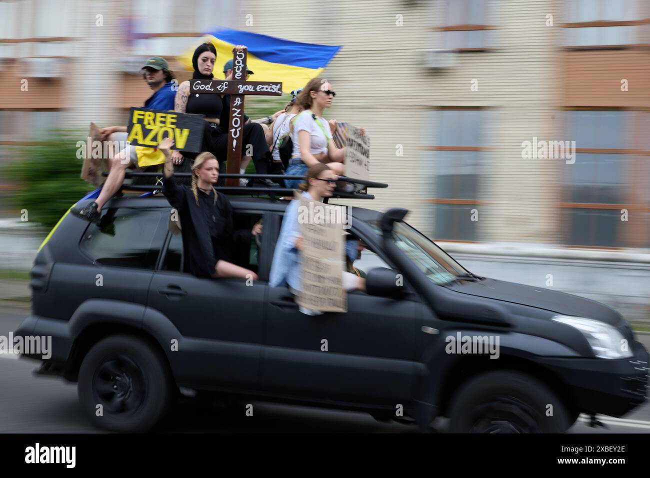 Ukrainian activists ride on top of a car with national flag of Ukraine ...
