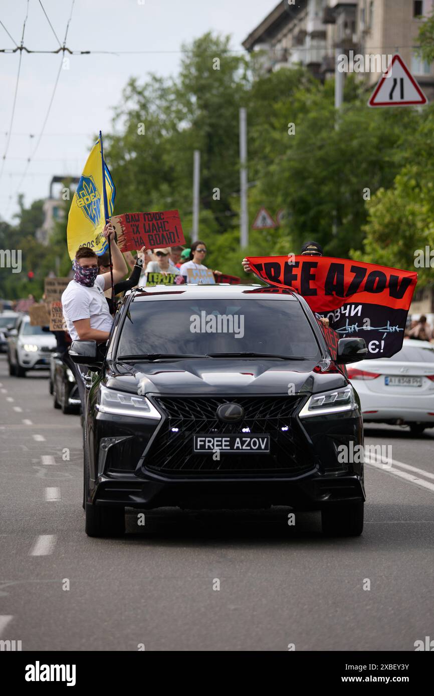 Ukrainian demonstrators ride on a Lexus SUV with flags and banners ...