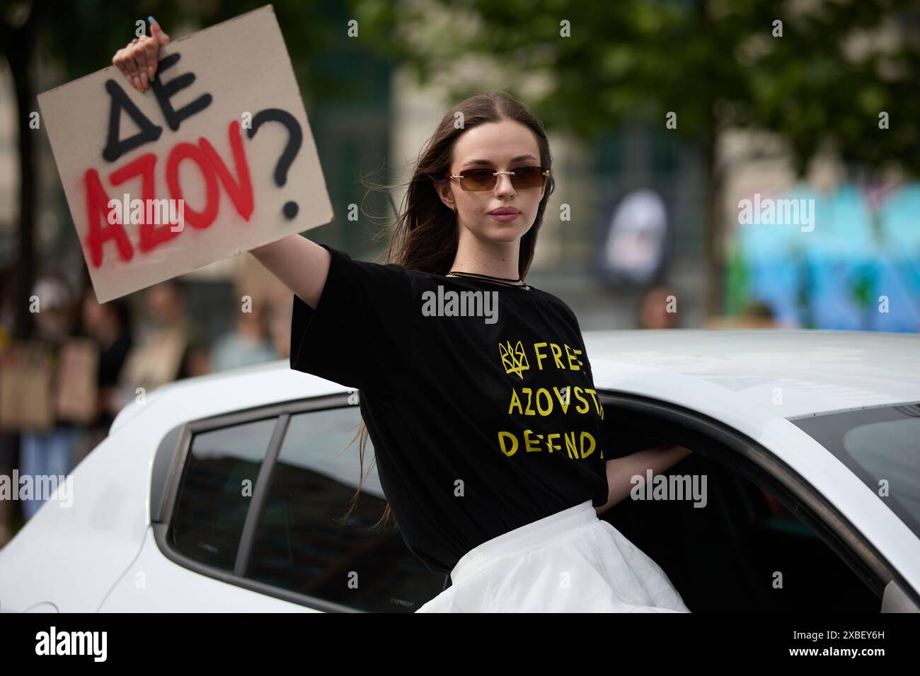 Young Ukrainian girl rides in a car and shows a sign "Where Is Azov ...