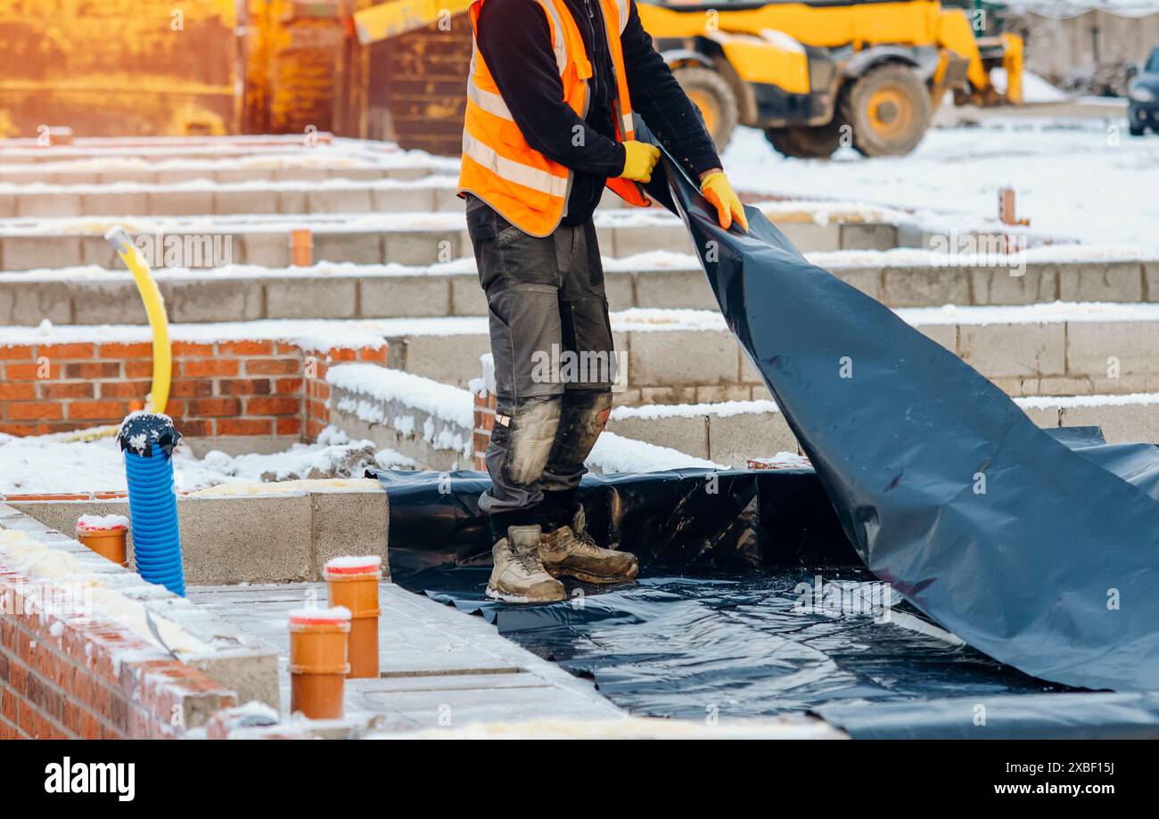 Waterproof installation at new house construction. Builders installing ...