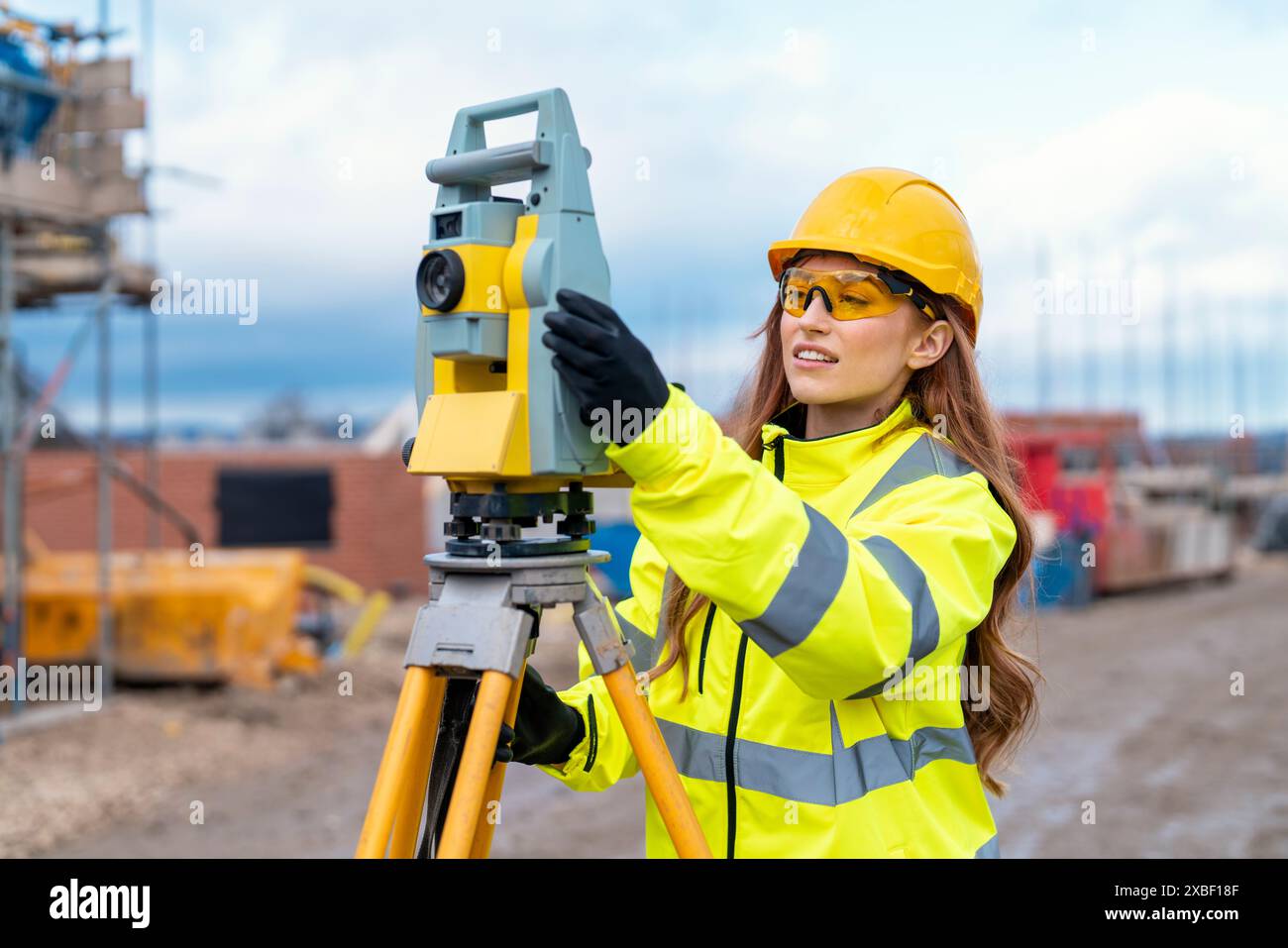 Female site engineer surveyor working with theodolite total station EDM ...