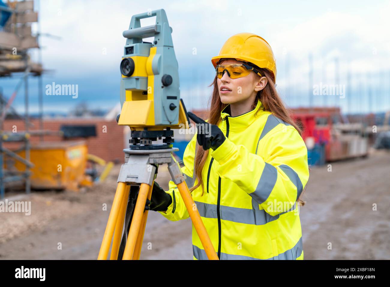 Female site engineer surveyor working with theodolite total station EDM ...