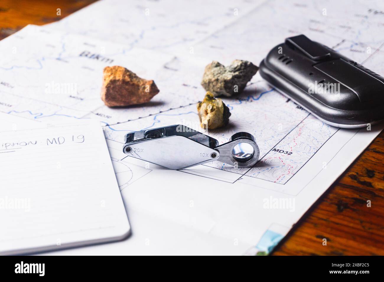 geologist using a loupe for rock and mineral identification and ...