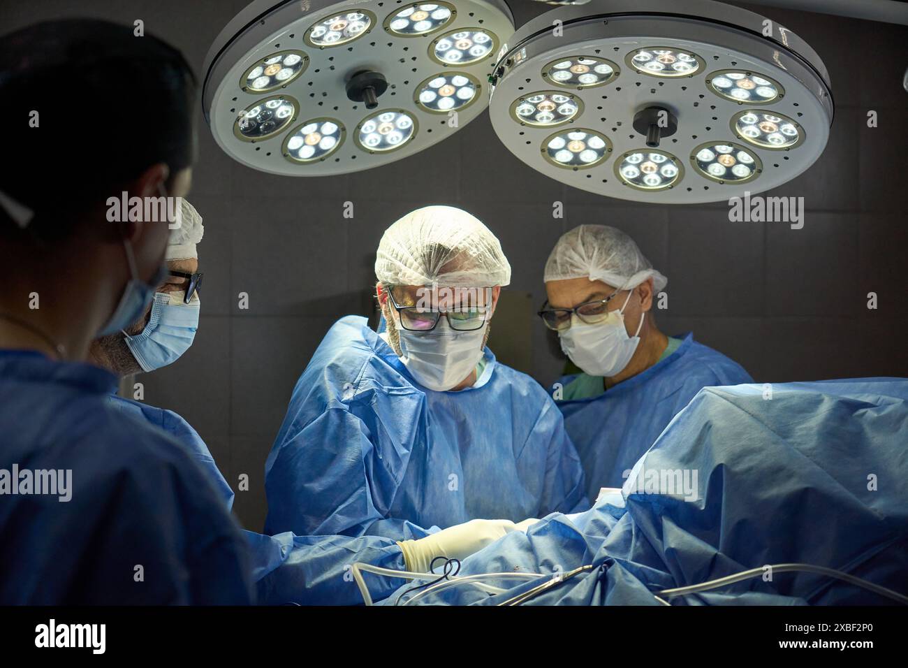 Surgical Team Performing Procedure in Operating Room With Bright Lights ...