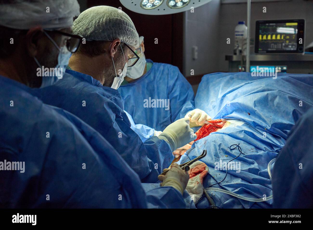 Operating surgeons performing incision hi-res stock photography and ...