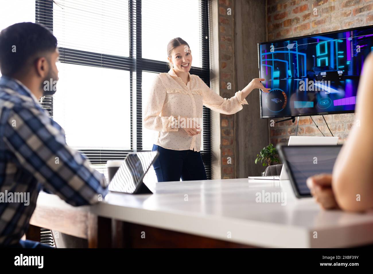Asian businesswoman presenting data on screen to a diverse team in ...