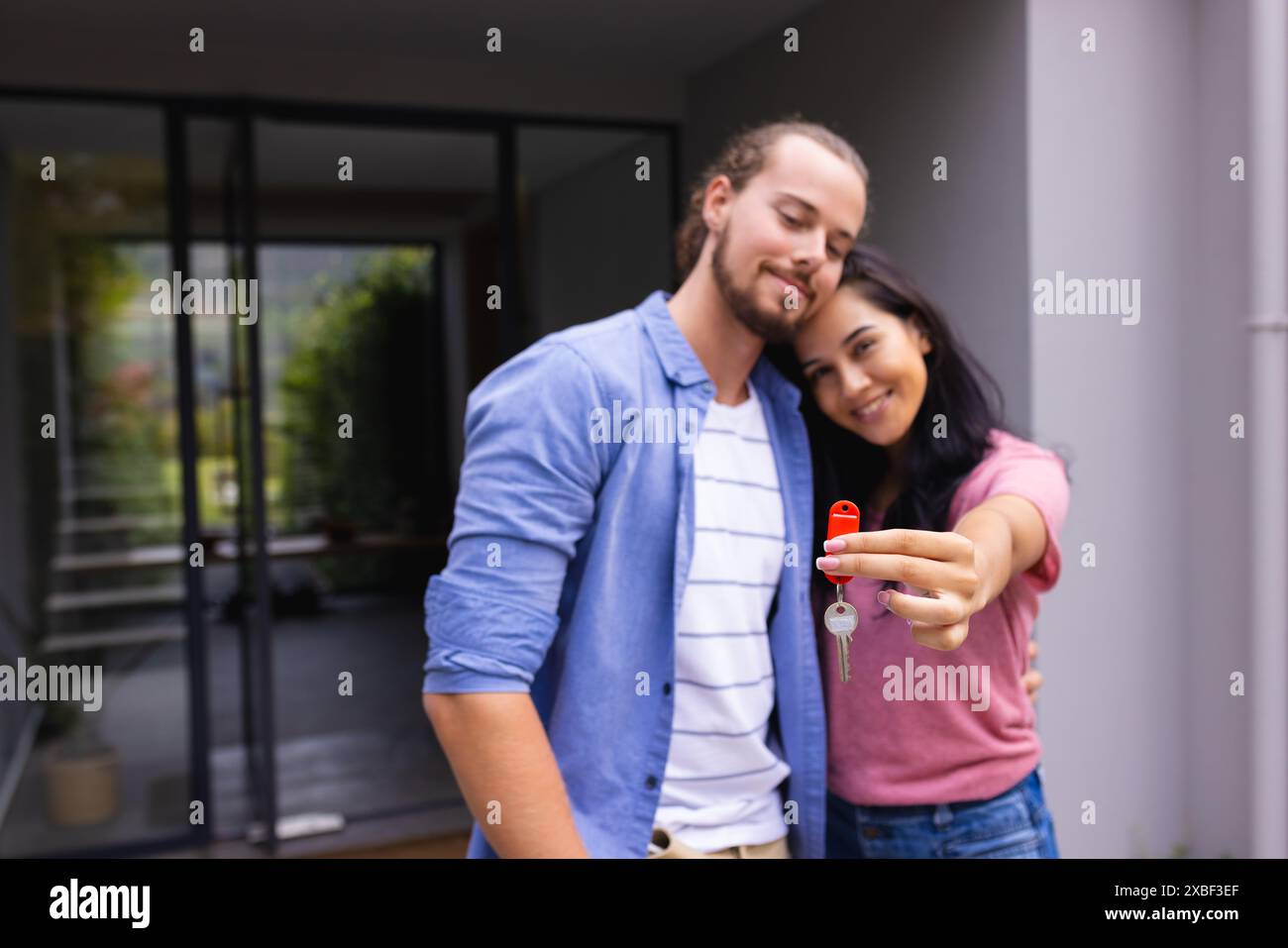 Young diverse couple hold house keys together, smiling, buying first ...