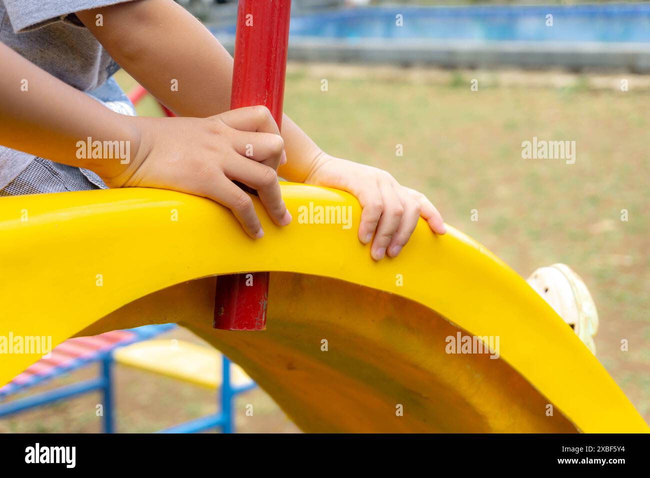 Big brother is playing with his younger sibling at the playground ...