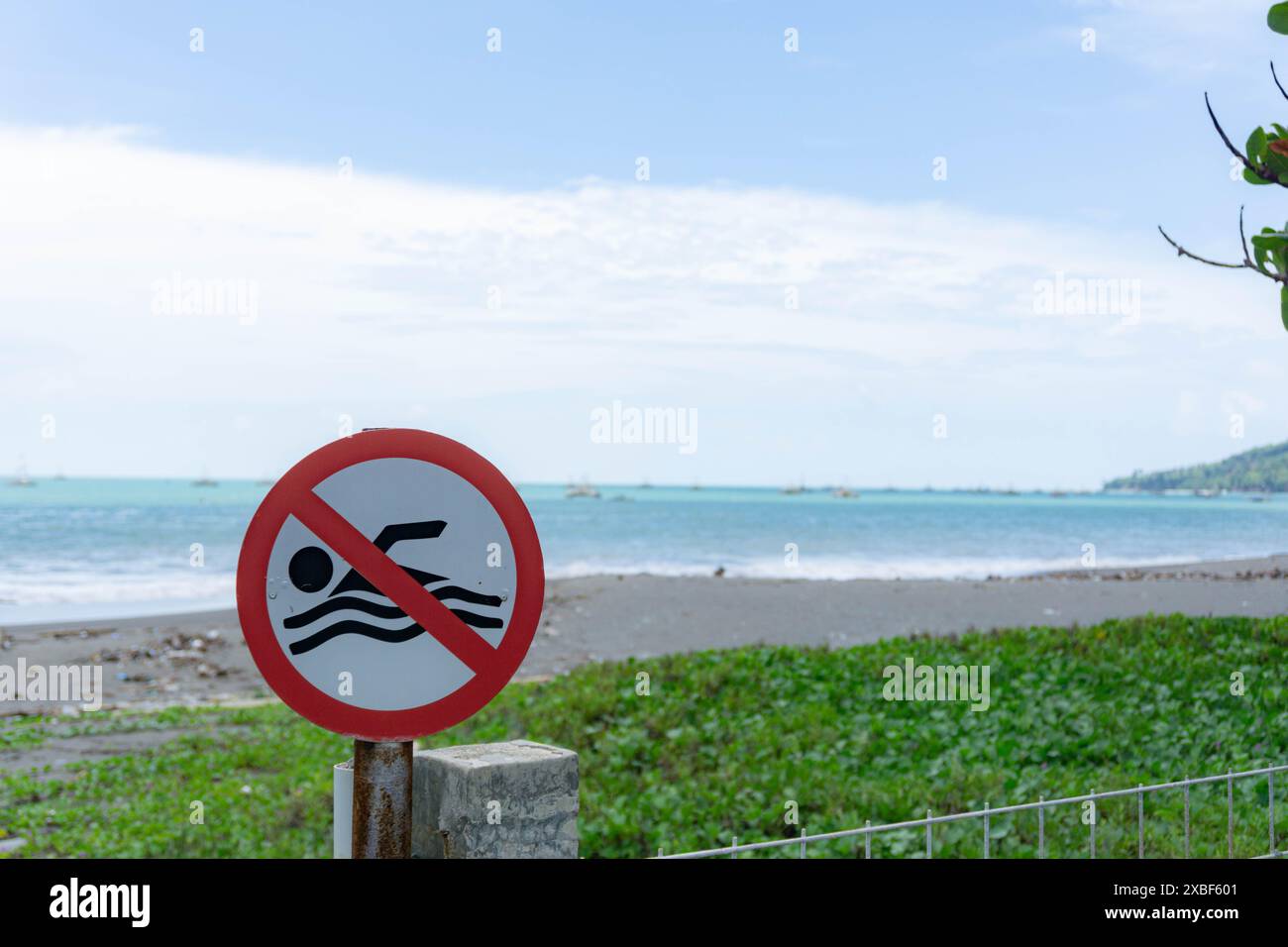 Sign, no Swimming on the Beach with a blurry beach as a background ...
