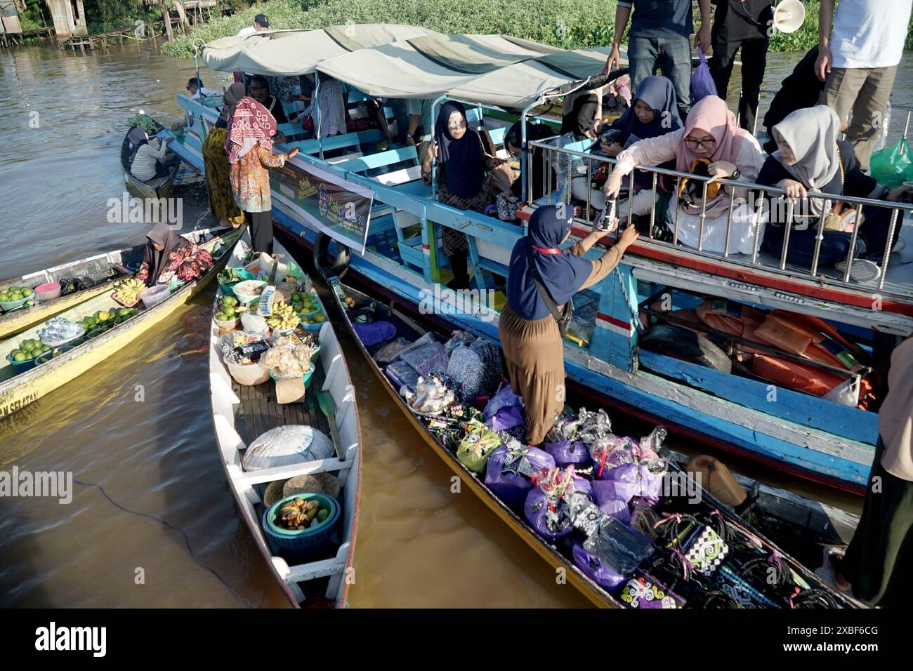 Banjar, Indonesia. 12th June, 2024. Vendors riding in klotok boats ...