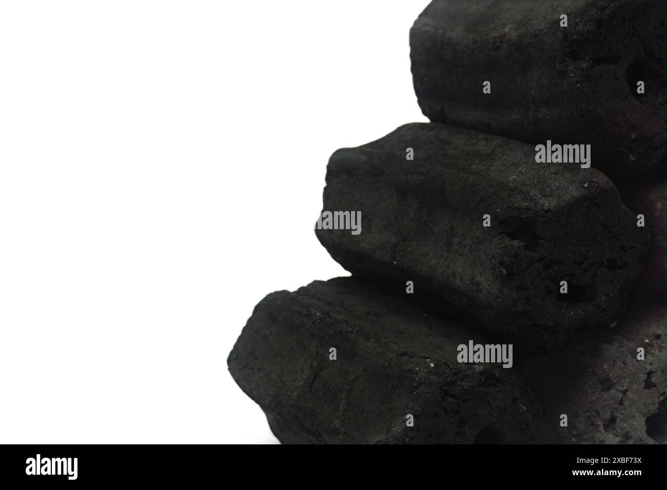 pile of hexagonal charcoal briquettes isolated on a white background ...