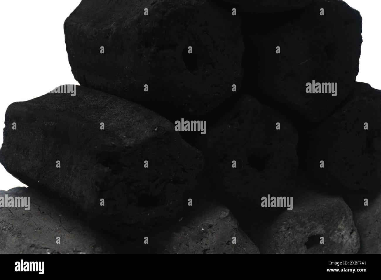 pile of hexagonal charcoal briquettes isolated on a white background ...