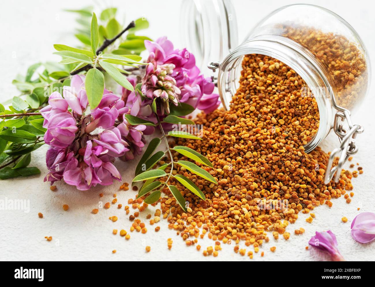 Healthy bee pollen grains. Bee pollen on a glass jar and acacia flowers ...