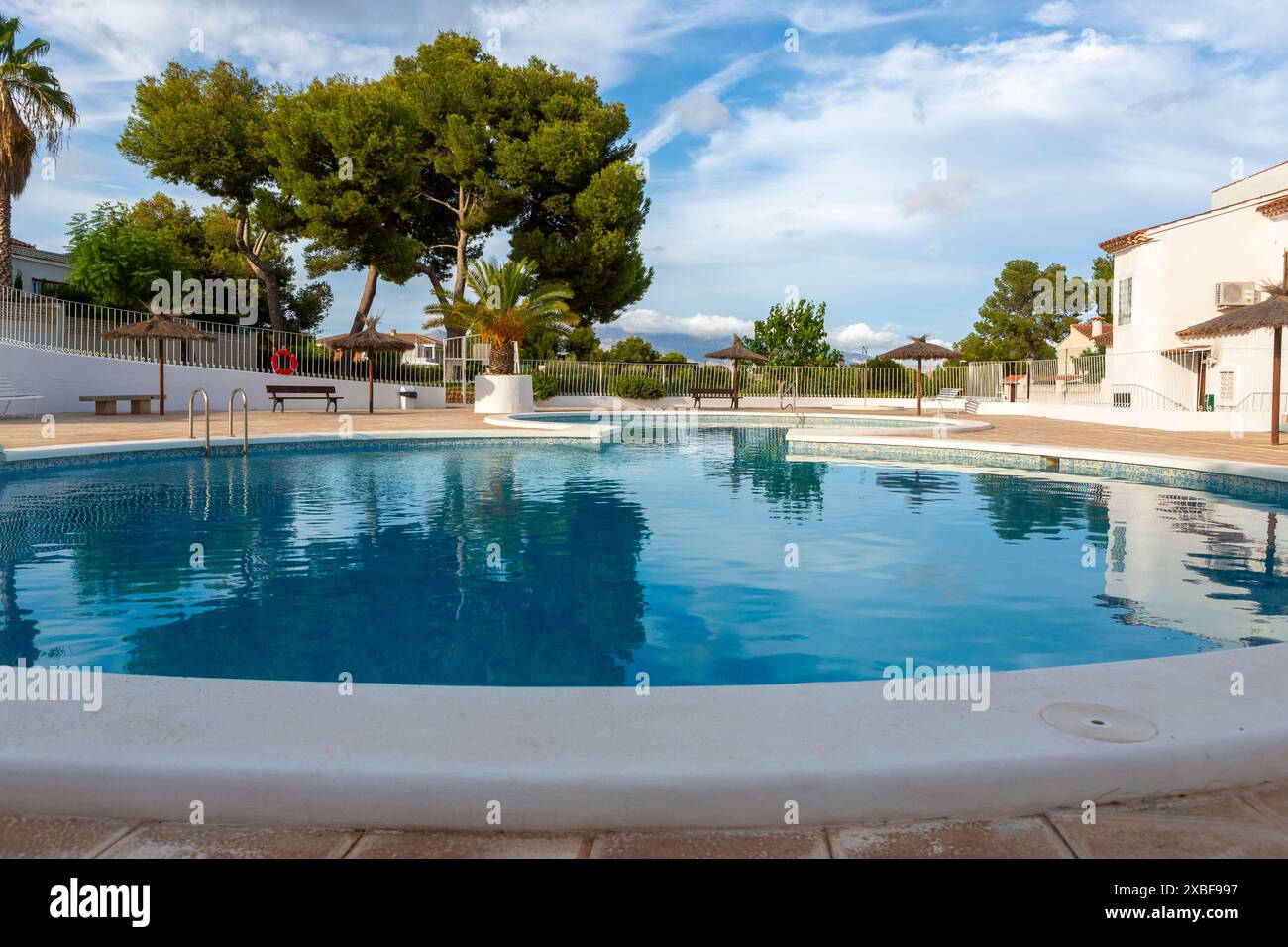 Residential swimming pool under a clear blue sky, surrounded by ...