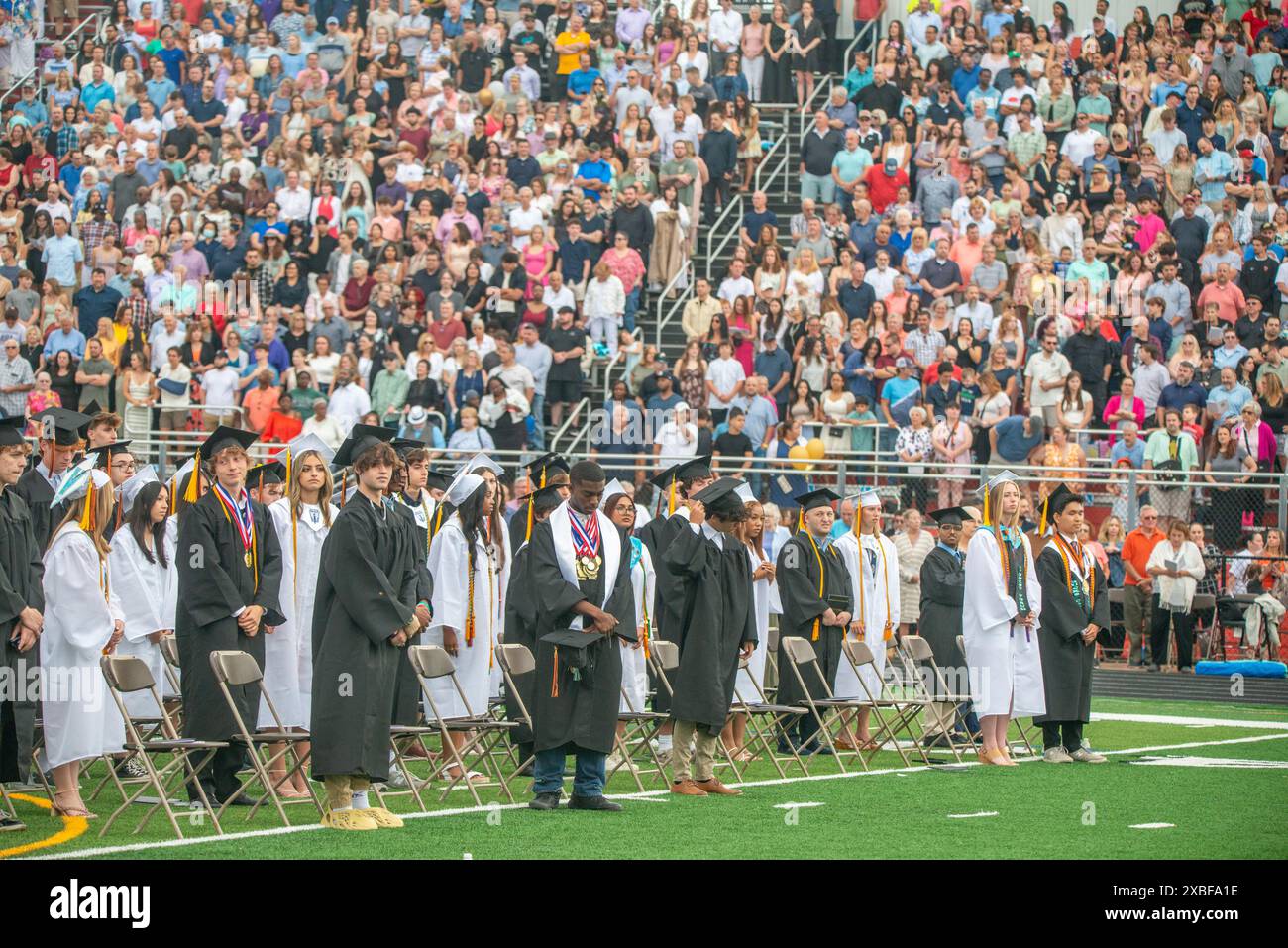 Graduates march into the school stadium to receive their diplomas ...